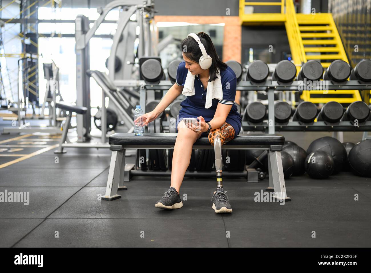 Disabled athlete patient with prosthetic leg doing exercise at gym ...
