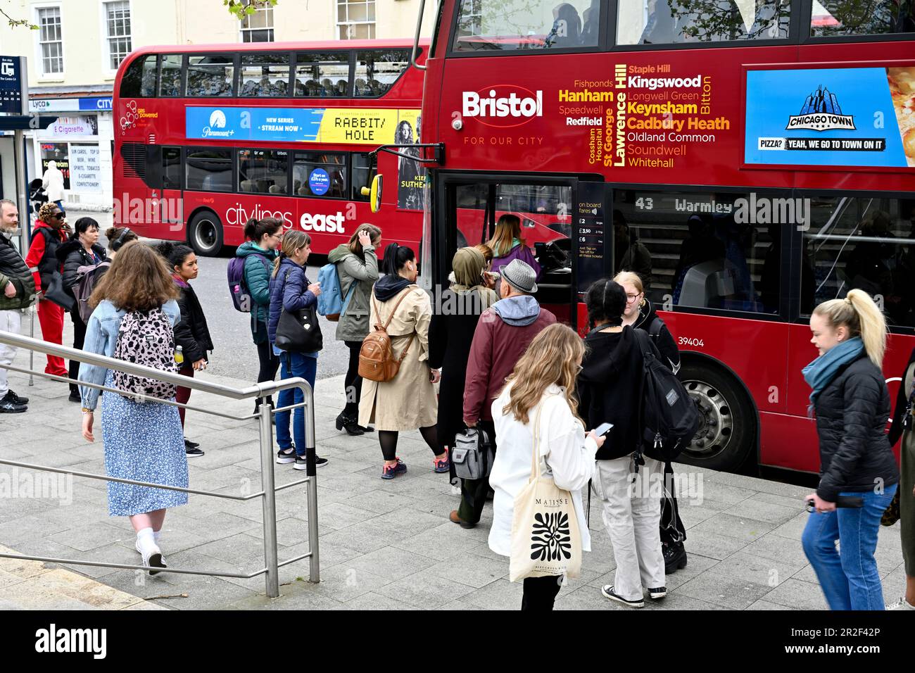 Bristol red local double decker buses with people queued for boarding ...