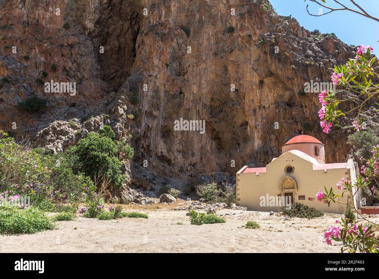 Flowering shrubs and chapel in the Agiofaraggo Gorge near Mátala, south ...