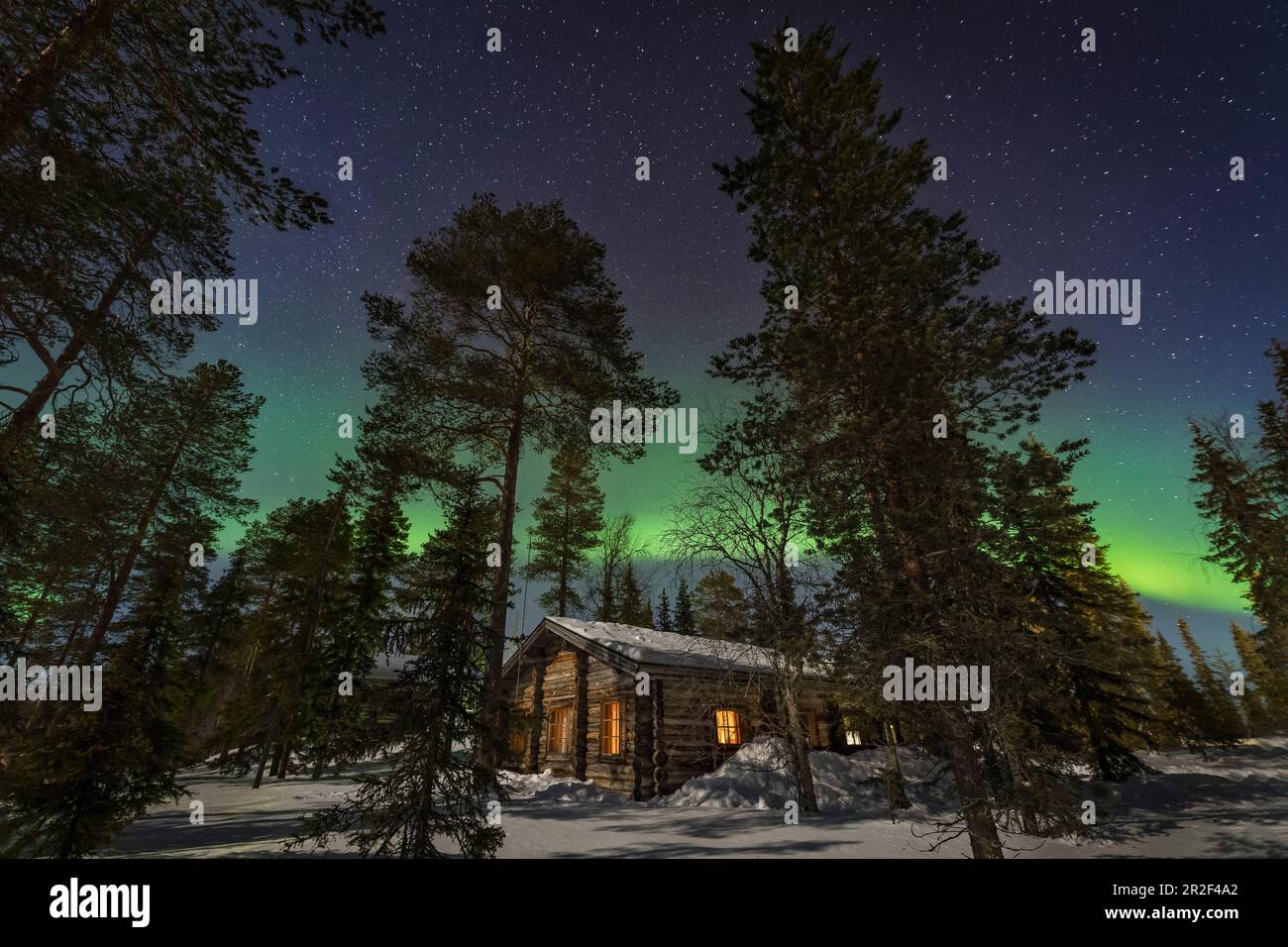 Cozy log cabin under northern lights, Luosto, Finland Stock Photo - Alamy
