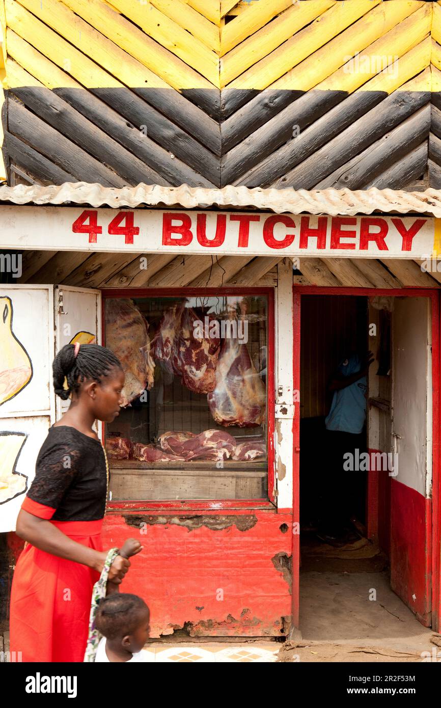 Kenyan woman with her child in front of a butcher shop in the slum ...