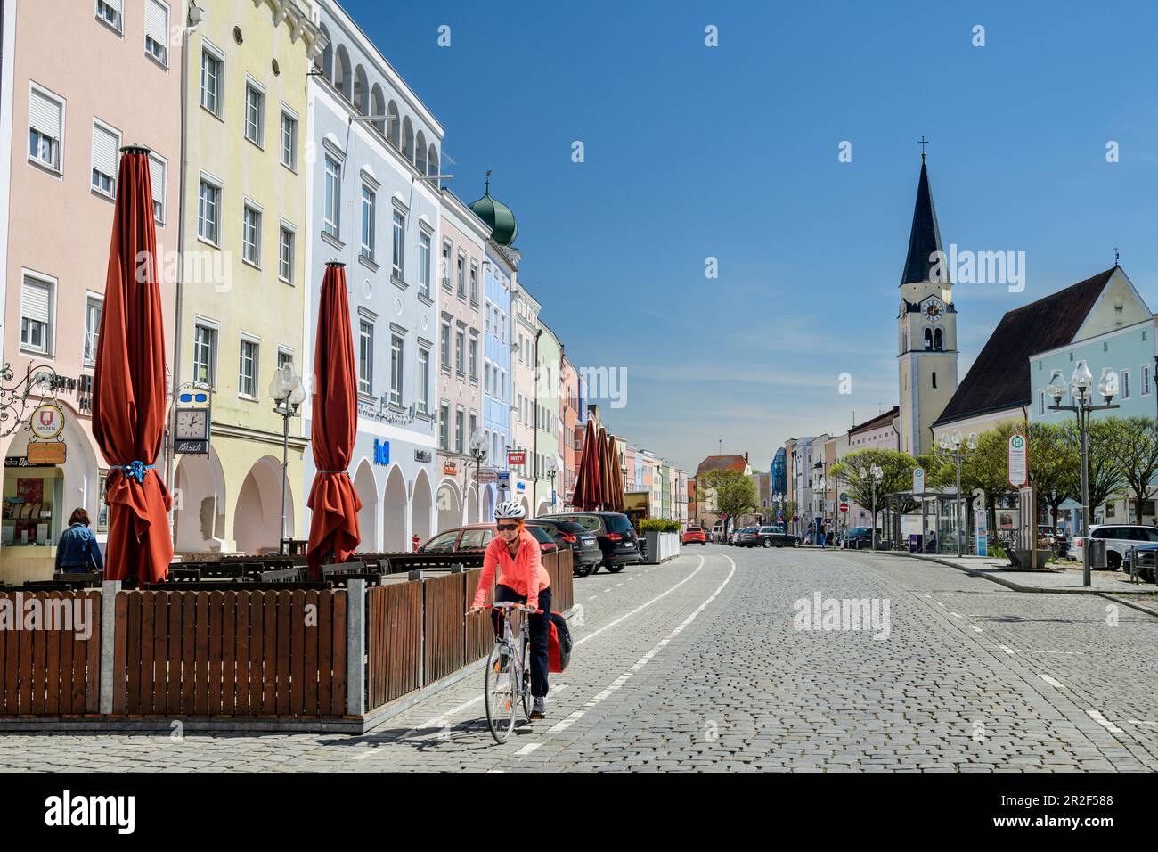 Woman cycling through town square of Mühldorf, Mühldorf, Benediktradweg ...