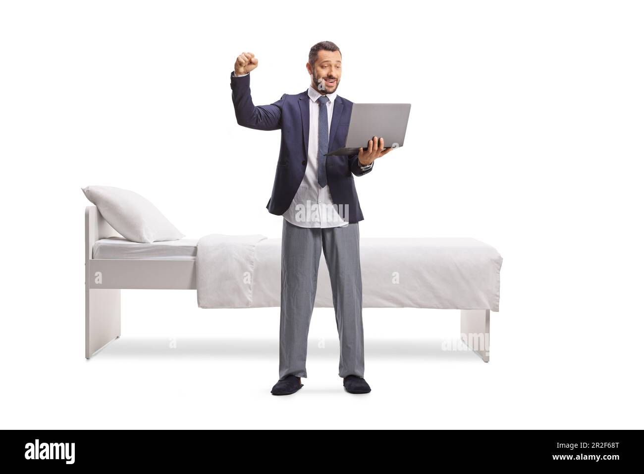 Man in a suit and bottom pajamas using a laptop computer and gesturing ...
