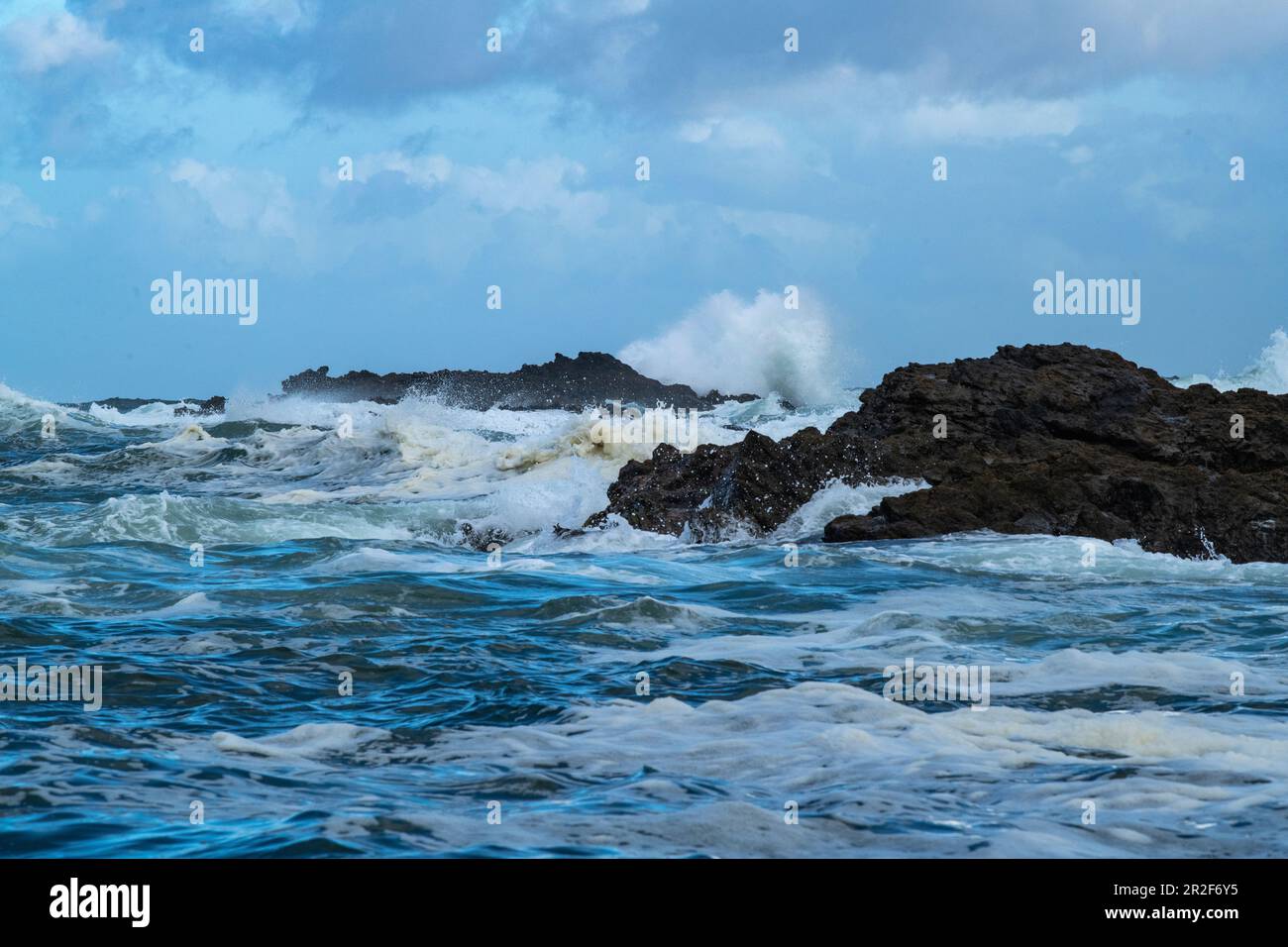 Rough ocean waves roll towards the rugged islands along the coast ...