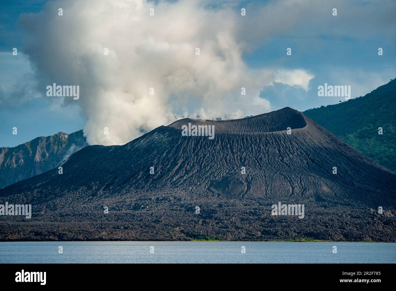 Smoke, steam and gases rise from the cone of an active volcano in ...