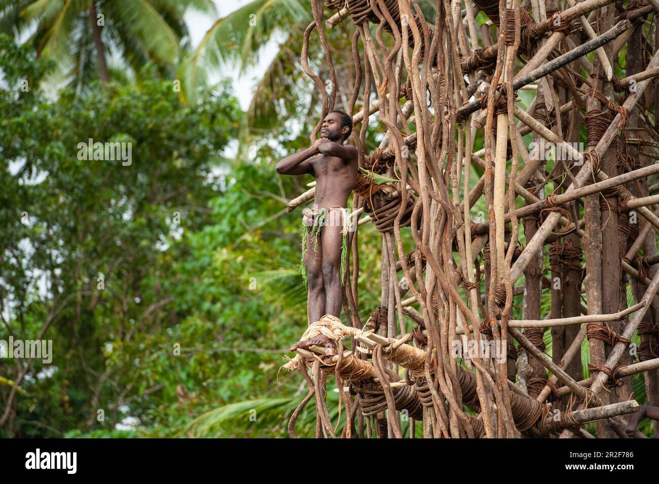Original bungee jumping: A young man stands on a wooden tower with only ...