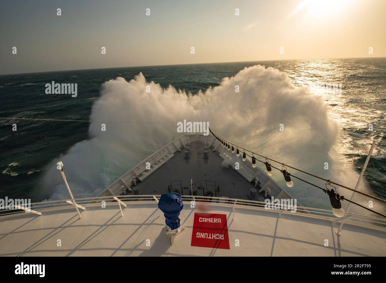 The front of an expedition cruise ship encounters a large wave and ...
