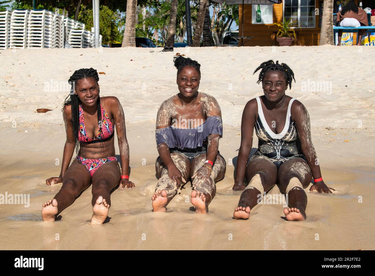 Three smiling young women sitting on the beach, Pigeon Point, Tobago ... Three smiling young women sitting on the beach, Pigeon Point, Tobago ...