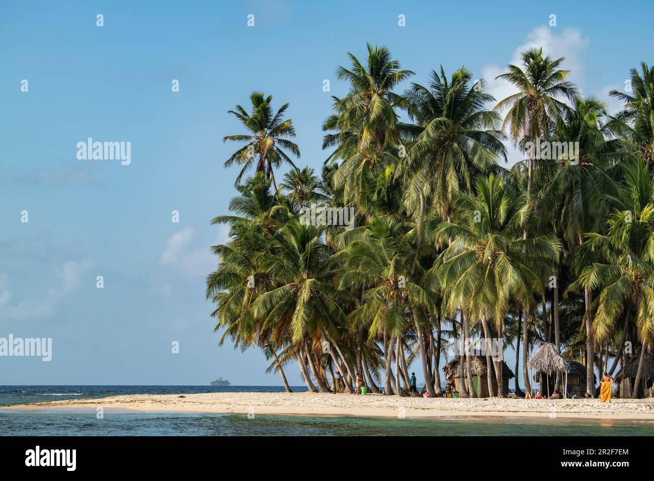 Small island beach scene with a hut, palm trees, a narrow beach and a ...