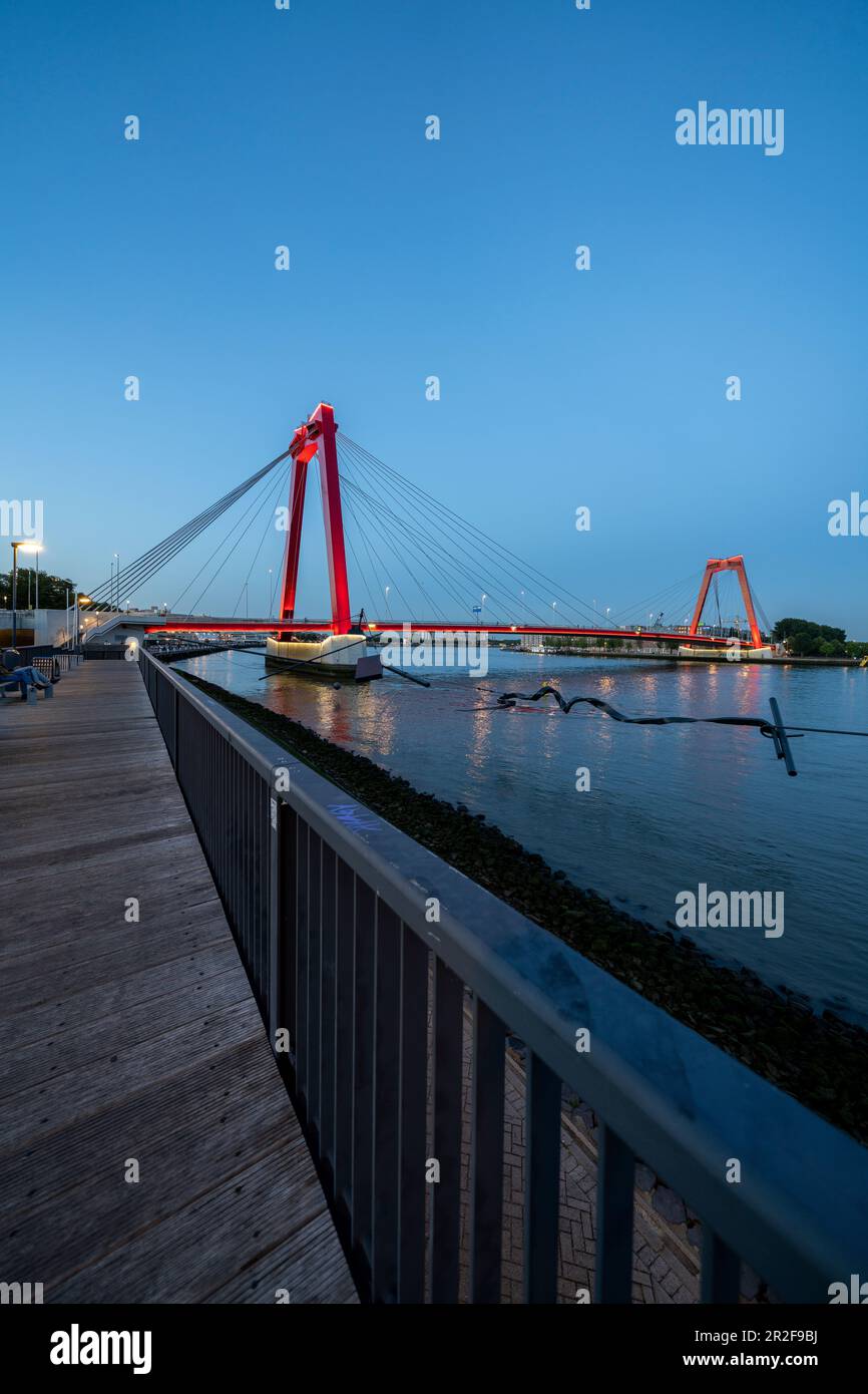 Illuminated, red Willemsbrücke during the blue hour, with plank path ...