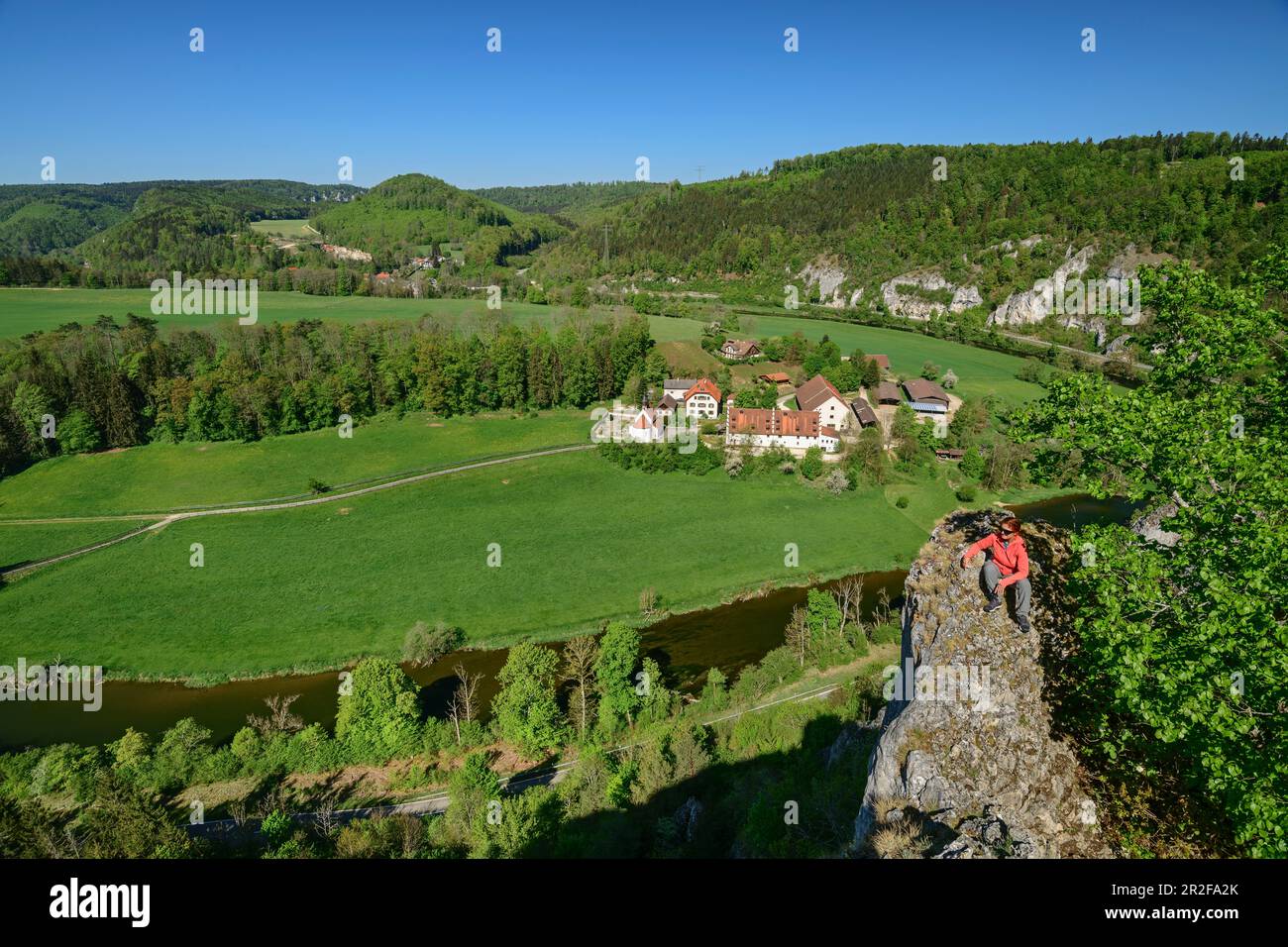 Woman sitting on rock tower, Danube in the background, Upper Danube ...