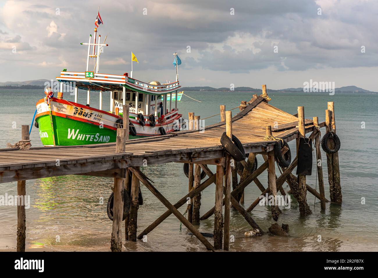 Curved jetty with boat on Noi Na beach in northwest Koh Samet, Thailand ...