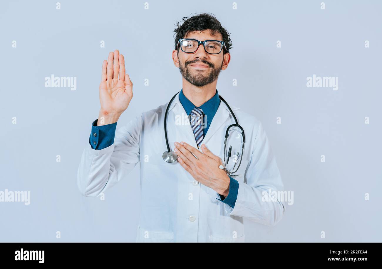 Doctor raising hand and swearing. handsome doctor making oath and ...