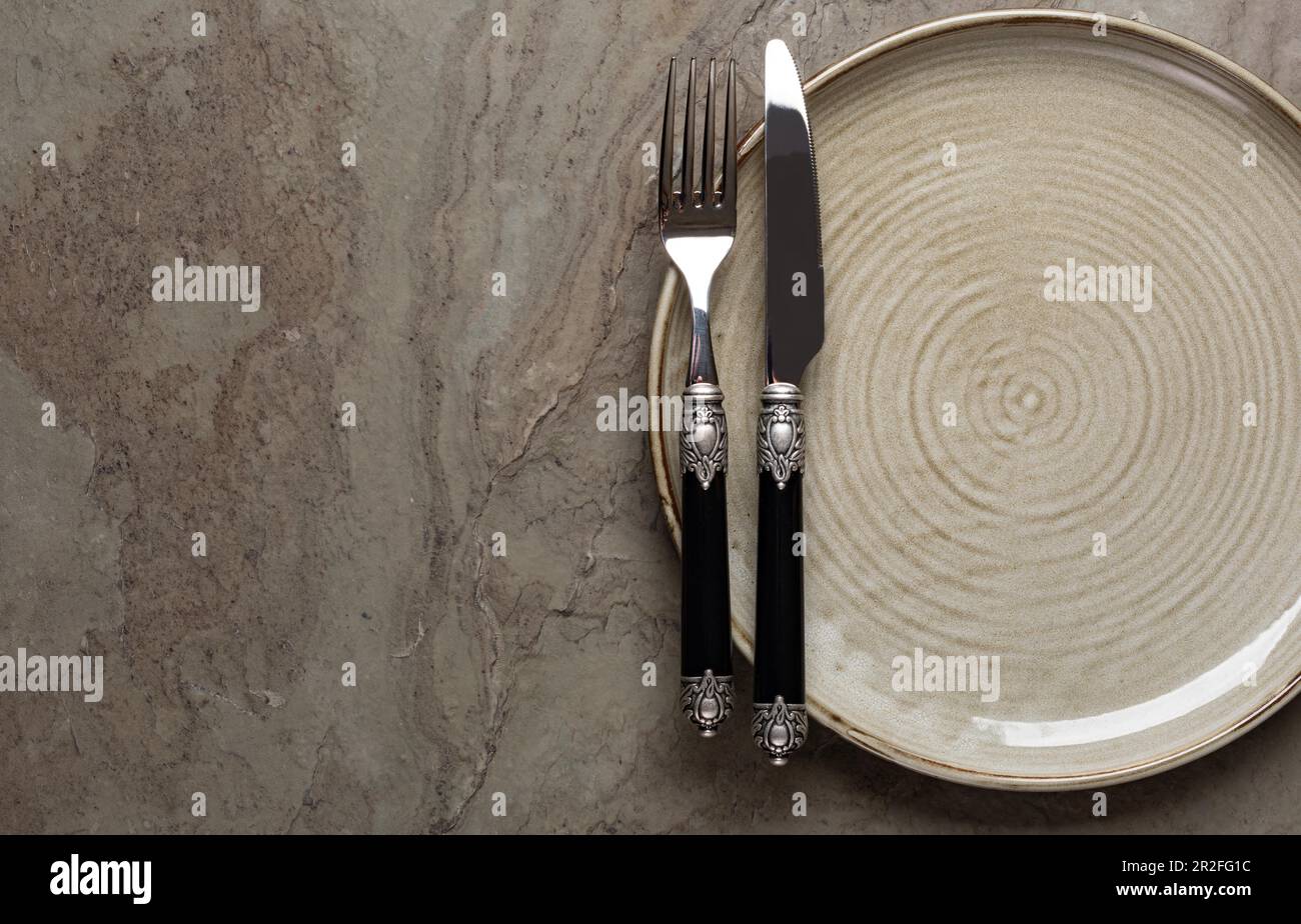 Table setting. plate, knife and fork on stone background Stock Photo ...