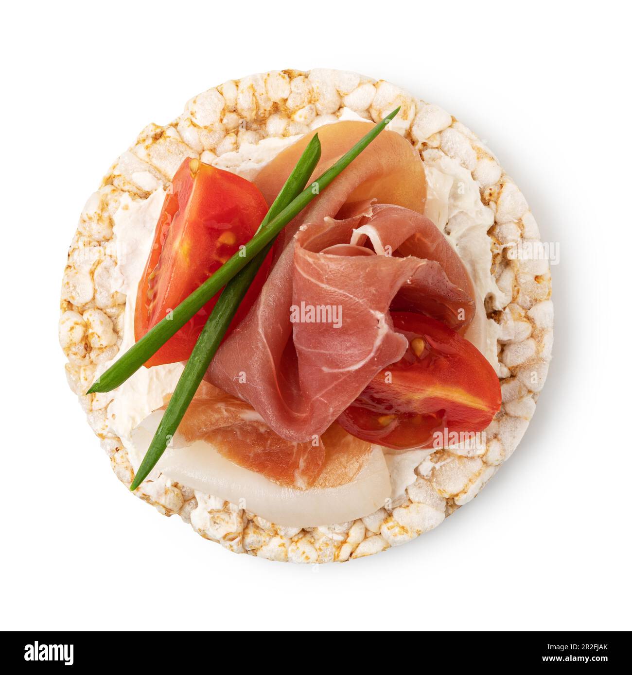 Rice cakes with cream cheese, prosciutto and tomato top view isolated ...
