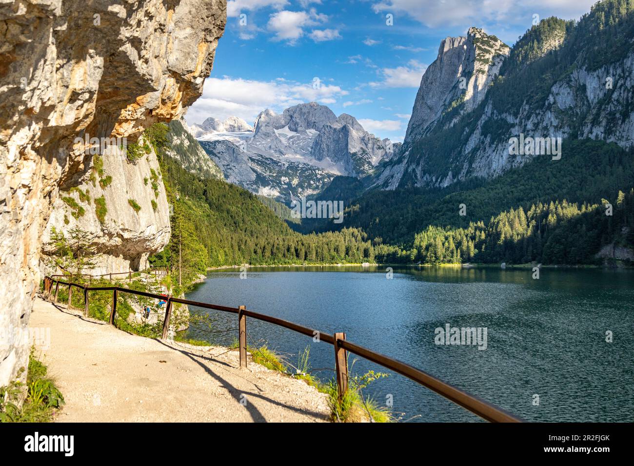 Large Gosau lake with climbing walls and a path in the foreground. View ...