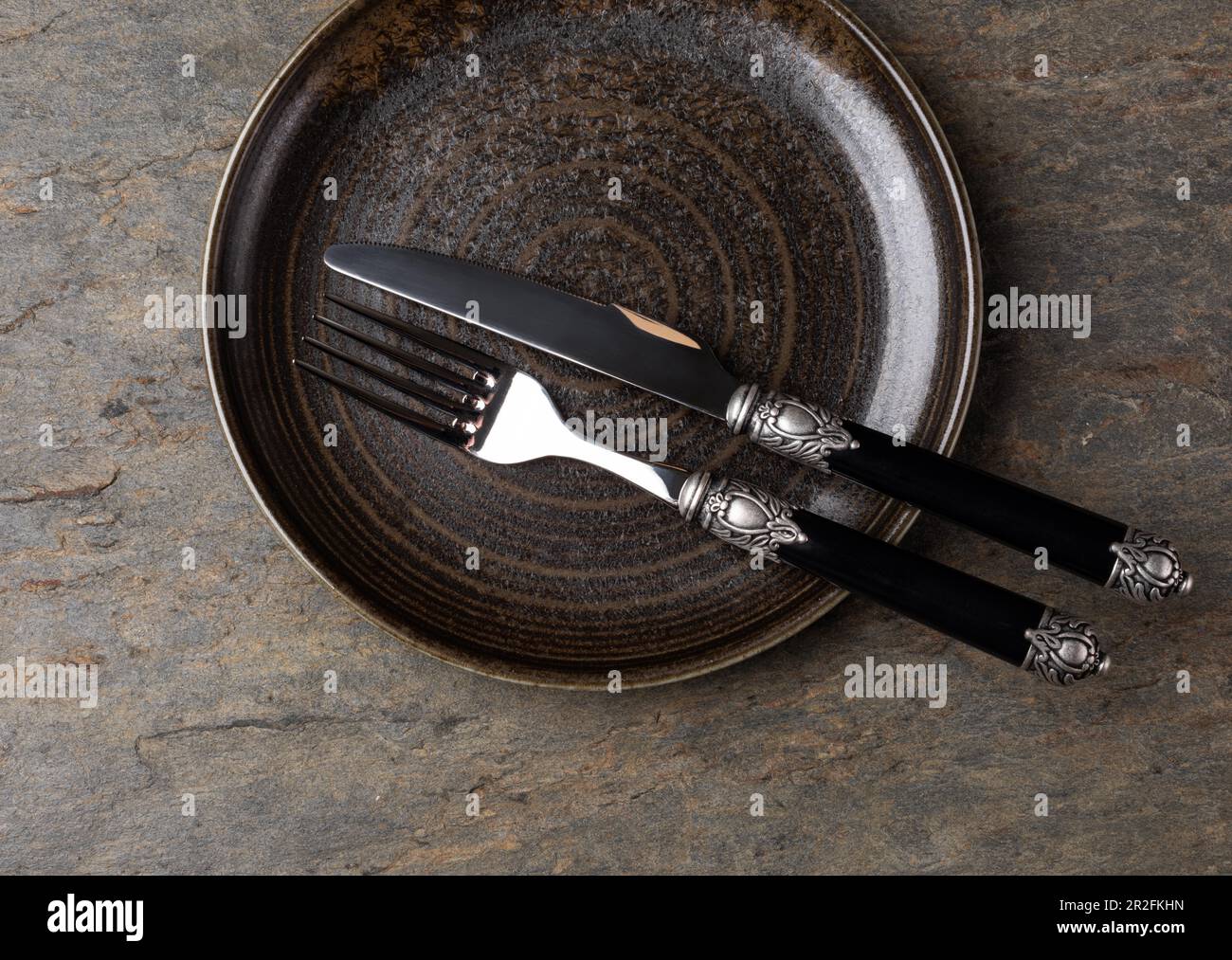 Table setting. plate, knife and fork on stone background Stock Photo ...