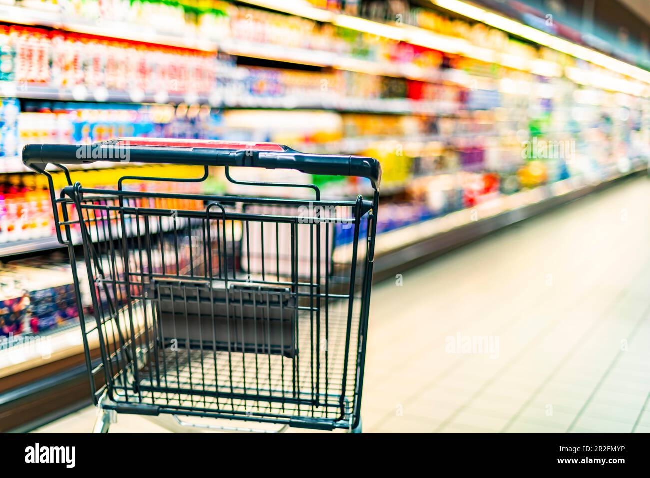 A shopping cart by a store shelf in a supermarket Stock Photo - Alamy