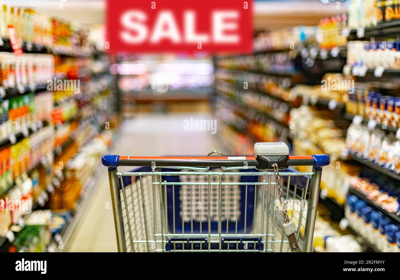 A shopping cart by a store shelf in a supermarket Stock Photo - Alamy