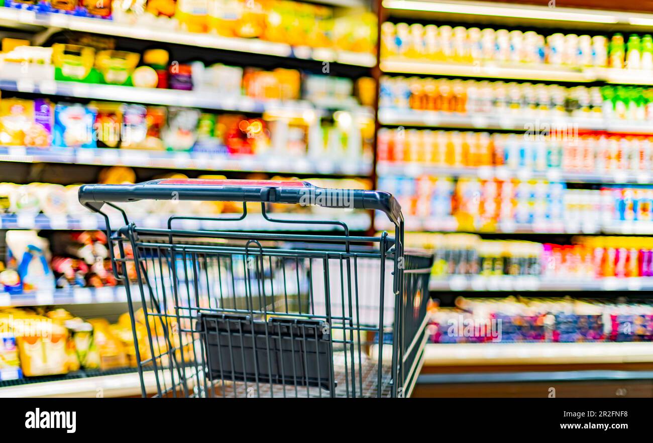 A shopping cart by a store shelf in a supermarket Stock Photo - Alamy