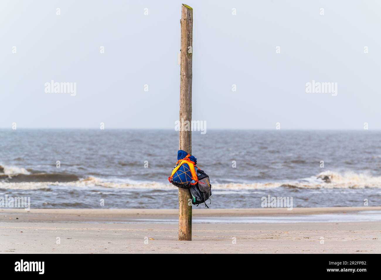 Backpacks hang on a pole in the North Sea, St. Peter-Ording, North Sea ...