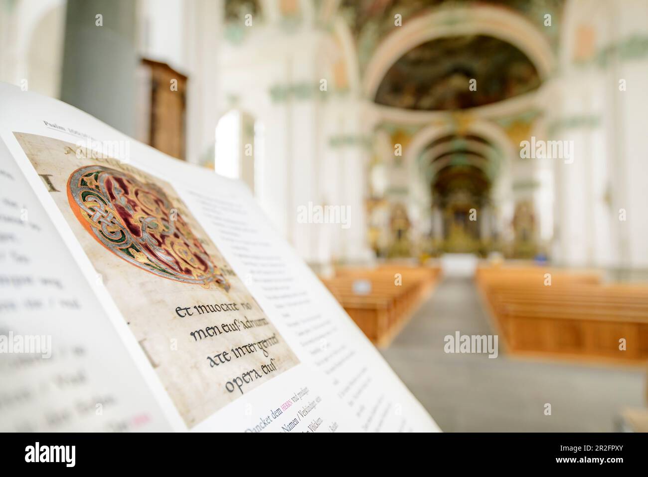 Decorated page of a medieval book with the chancel out of focus in the ...
