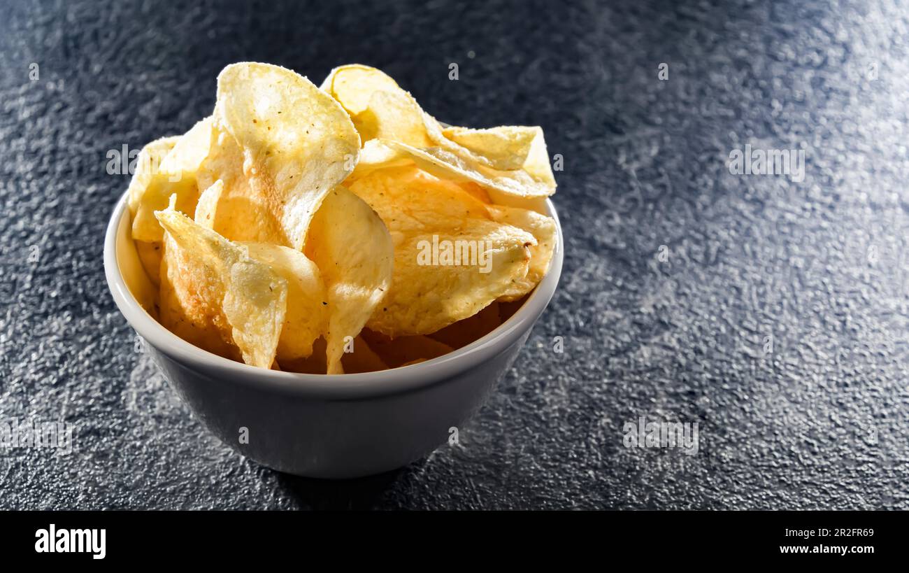 Composition with a bowl of potato chips Stock Photo - Alamy