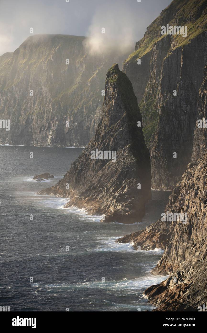 Steep coast in the west of the island of Vágar with the waterfall ...