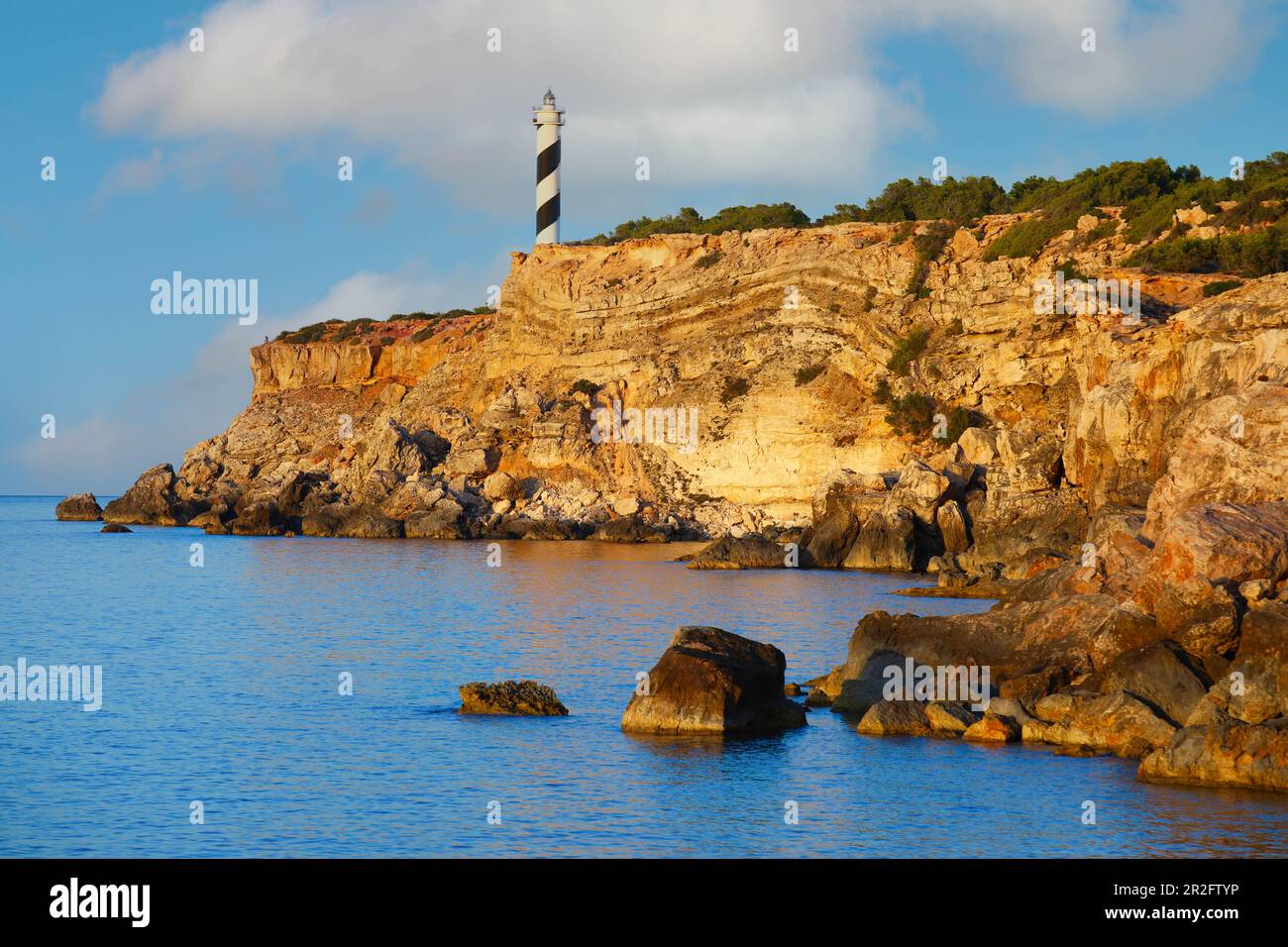 Lighthouse at sunset on top of the cliffs with blue ocean Stock Photo ...