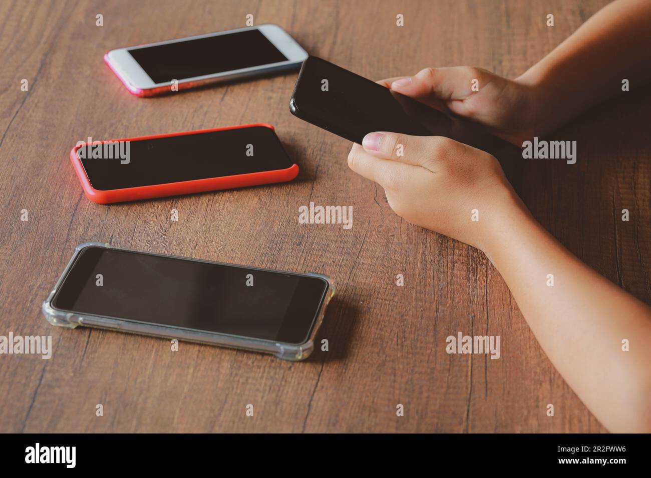 Hand of children holding a modern smart phone with three smart phones ...