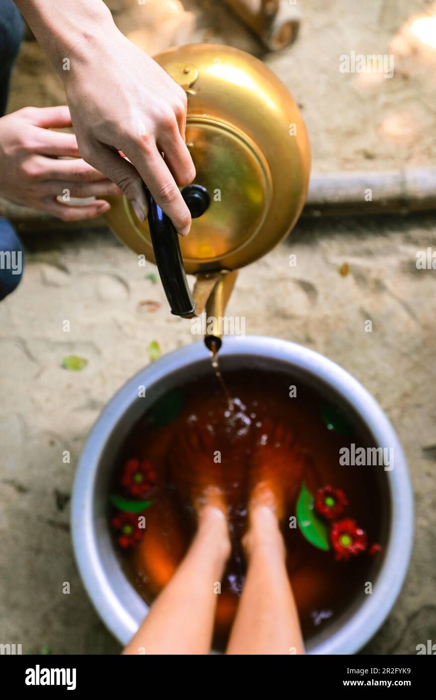 Selective focus golden kettle pouring water into aromatic foot soak ...
