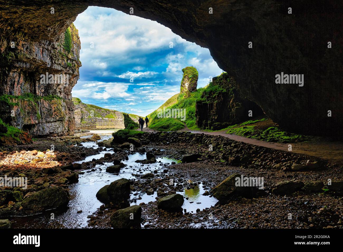 Visitors in the cave entrance, limestone cave Smoo Cave, backlight ...