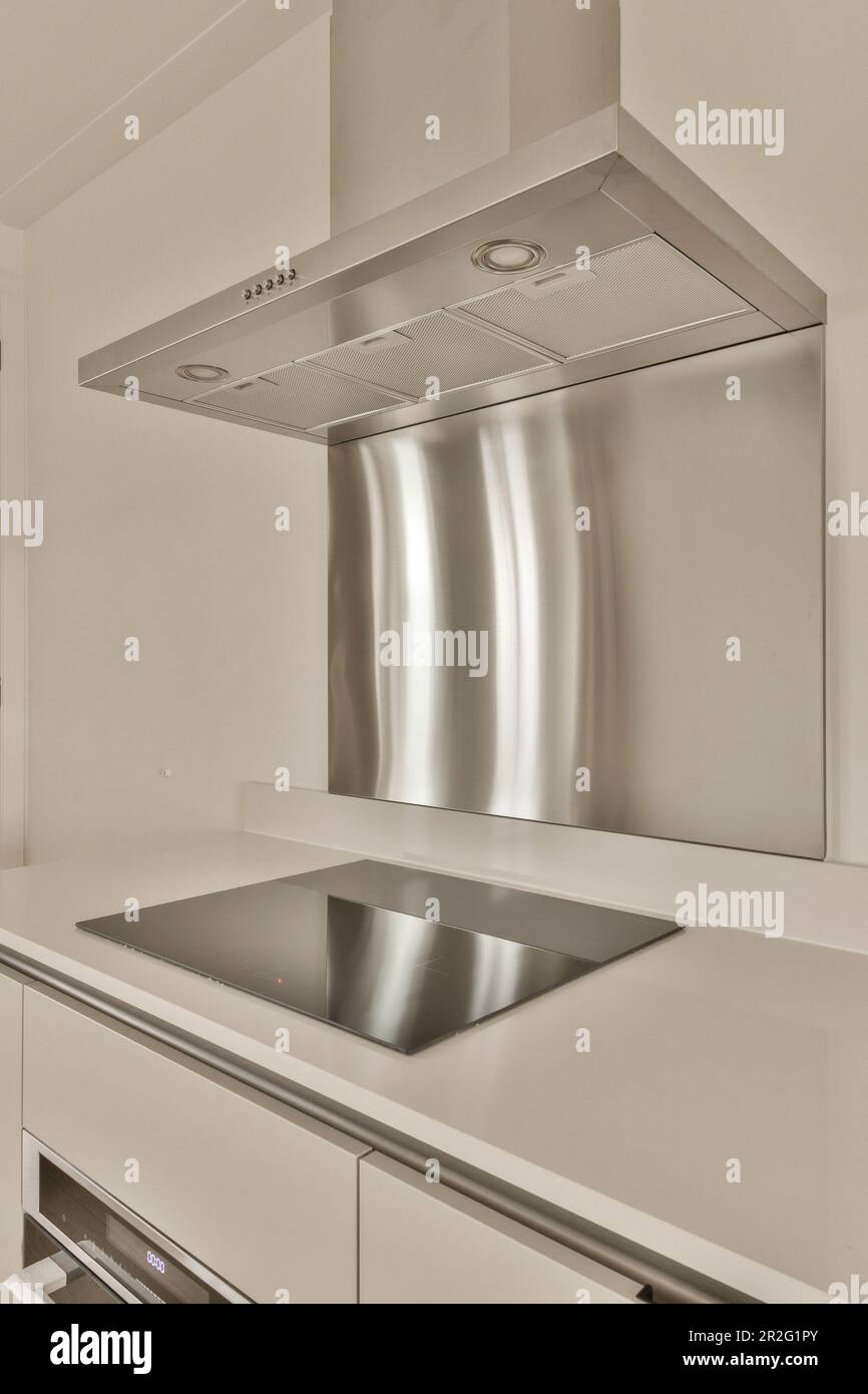 a modern kitchen with stainless steel hoods and appliances on the ...