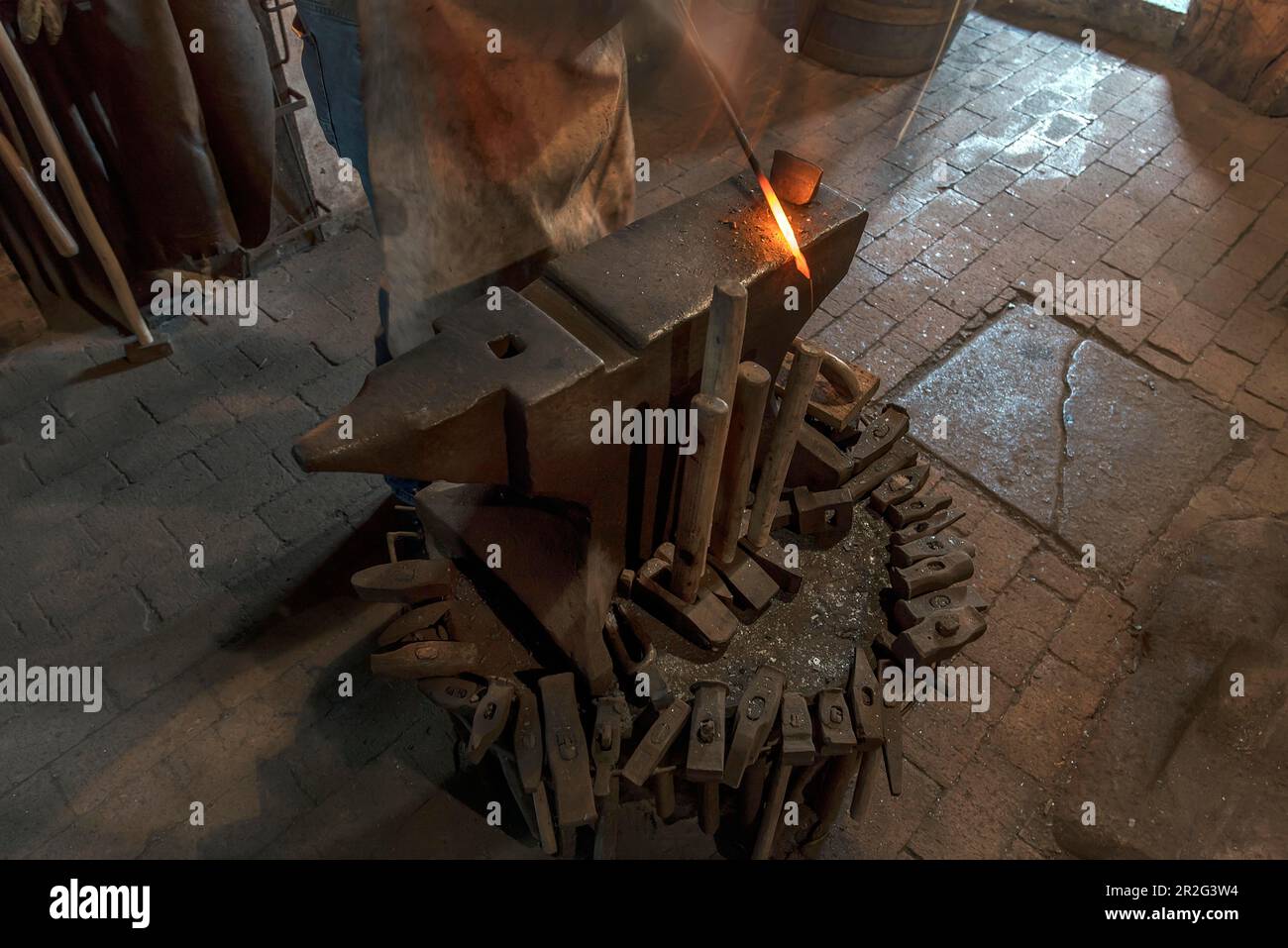Glowing iron on the anvil with forging hammers in a historic hammer ...