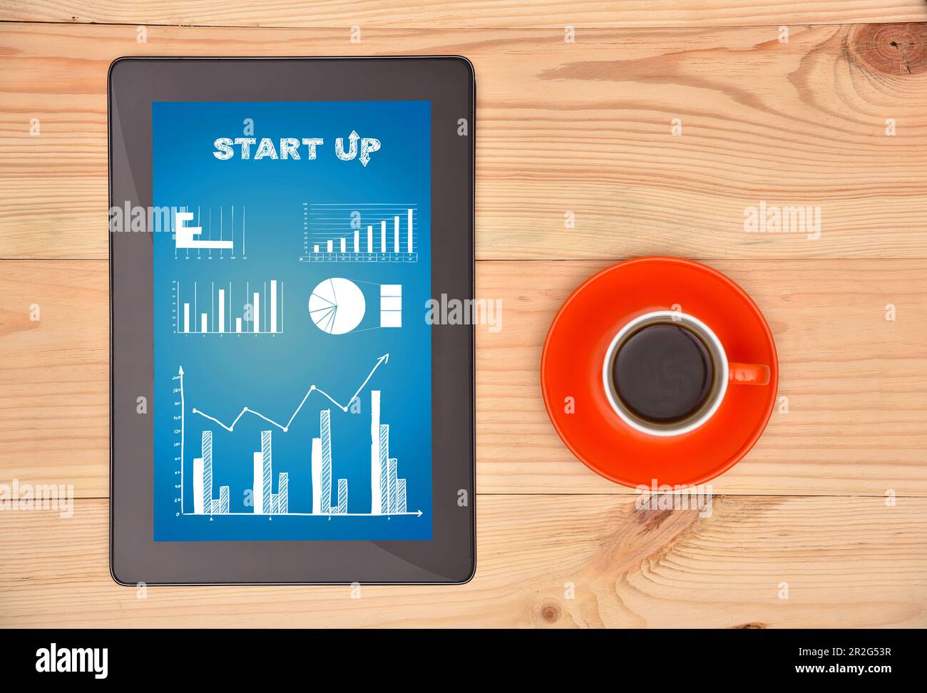 Coffee and tablet with start up chart on table, above view Stock Photo ...