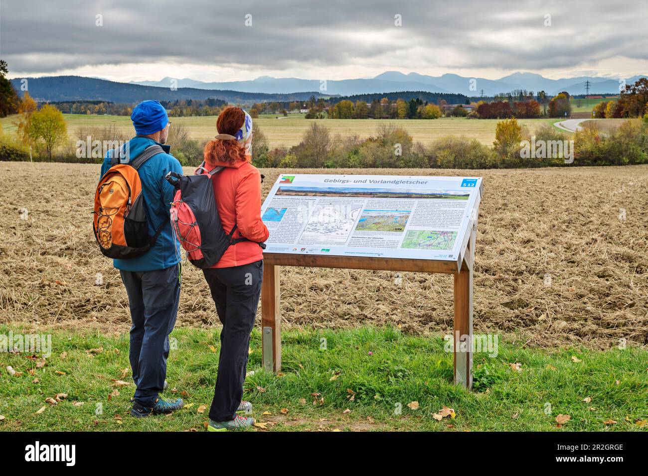 Man and woman hiking reading information board on the Holzkirchen ...