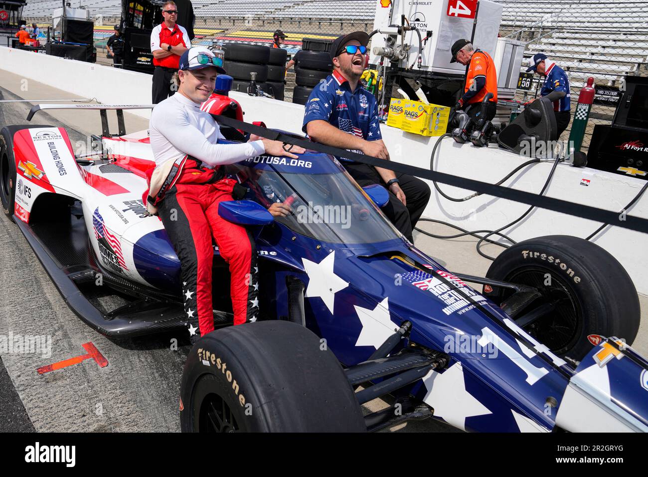 Santino Ferrucci, left, rides back to the garage area on top of his car ...