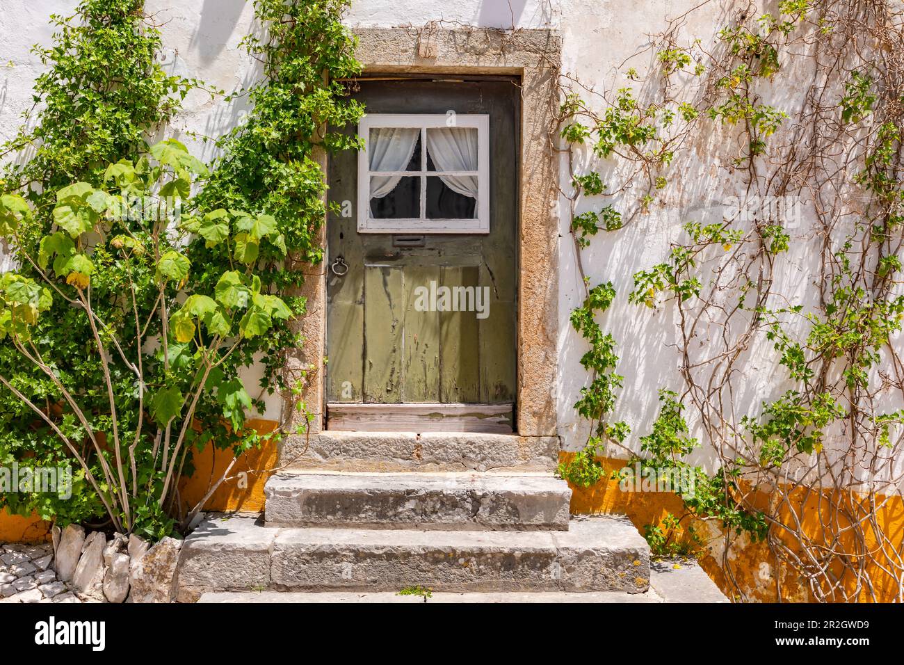 An old front door to an idyllic stone house in the historic town of Obidos, Portugal Stock Photo ...