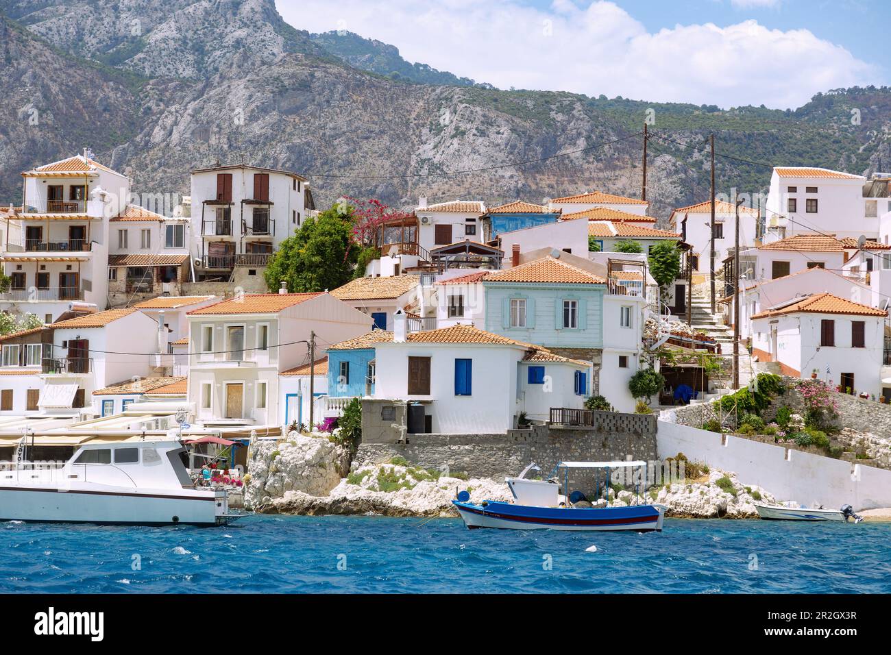 Kokkari old town with mountain backdrop and fishing boat in port on ...