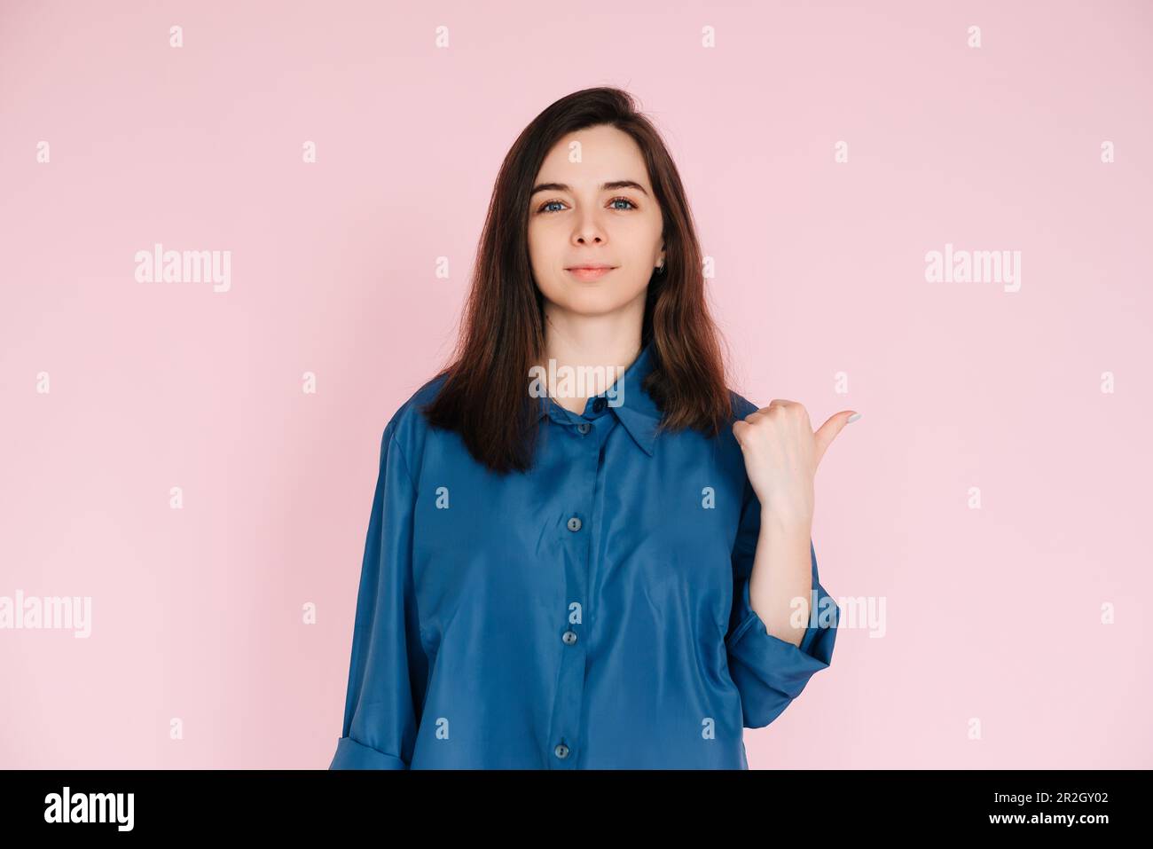 Young Businesswoman in Blue Shirt Pointing at Mockup, Symbolizing ...