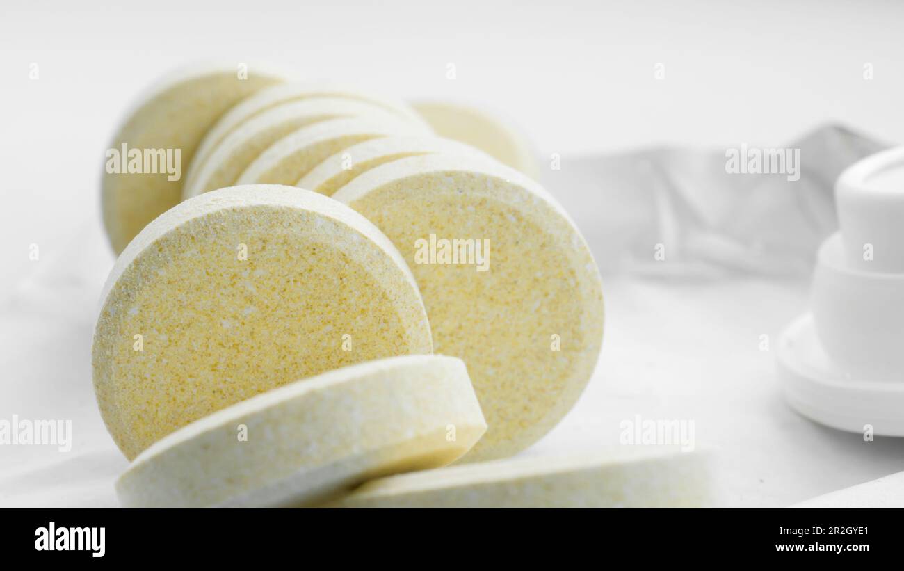 Heap of soluble effervescent vitamin tablets on a paper background ...