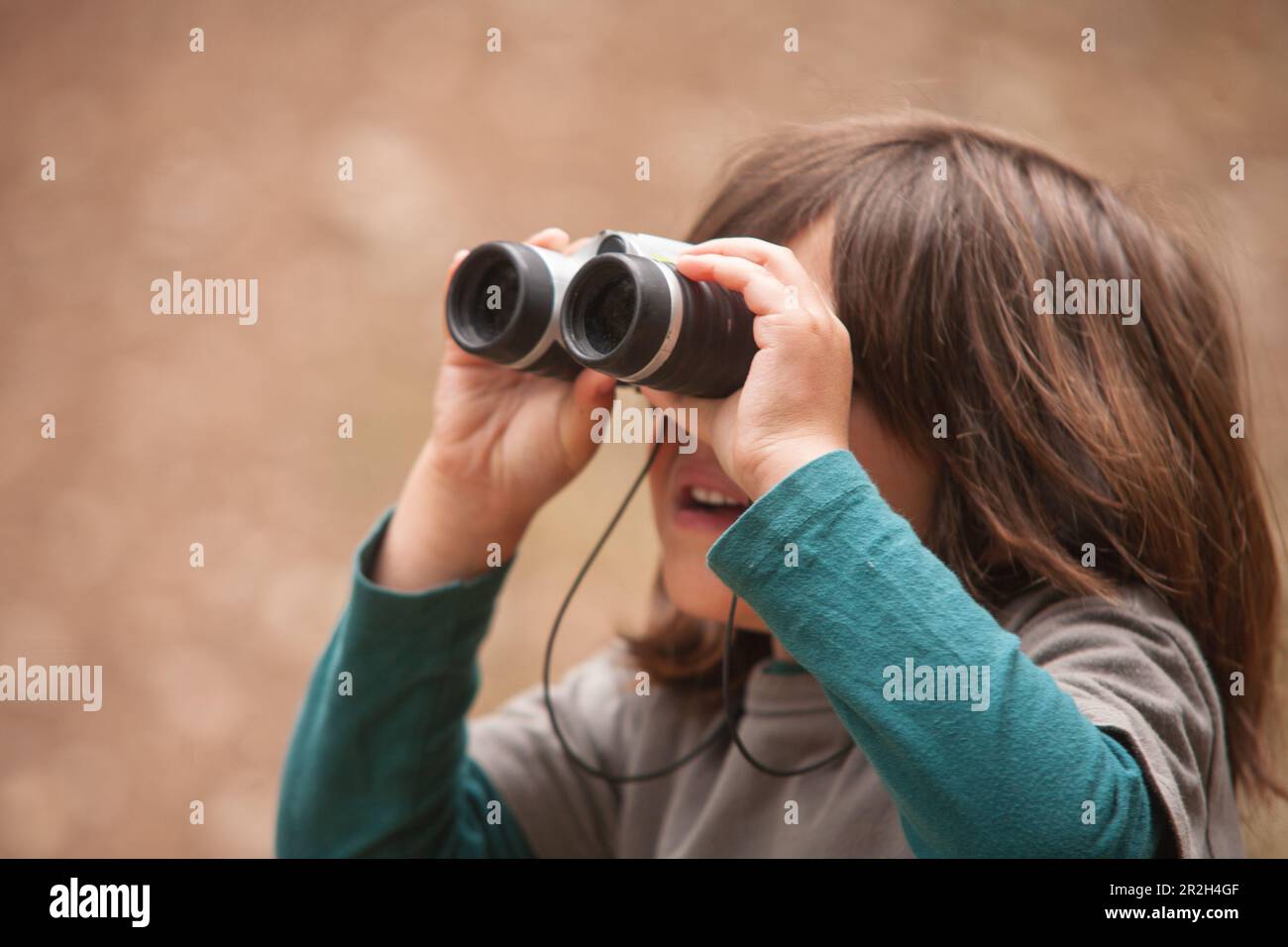A close-up of a child using binoculars to observe nature, immersing ...