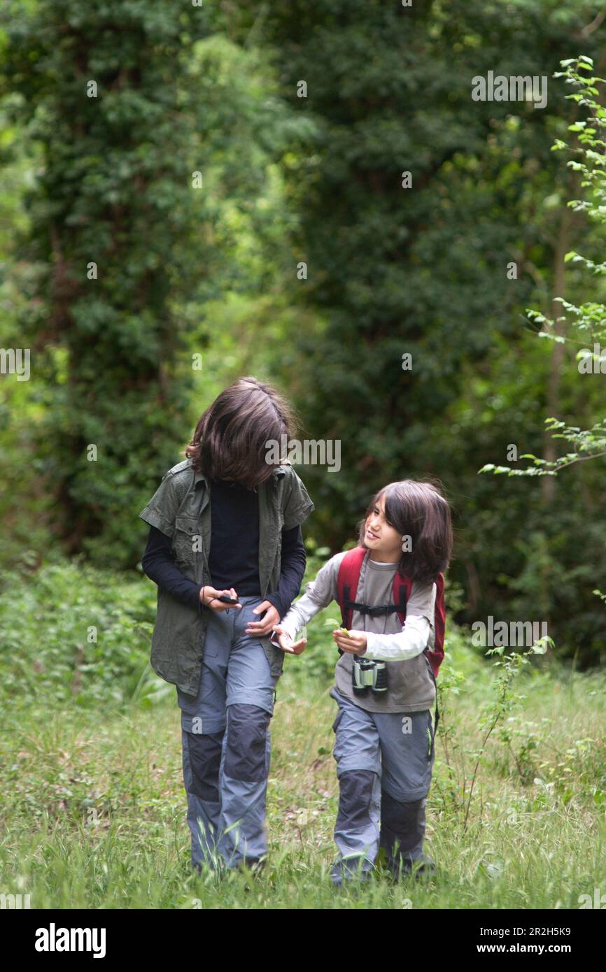 In a forest clearing, the older sibling shares the secrets of nature ...