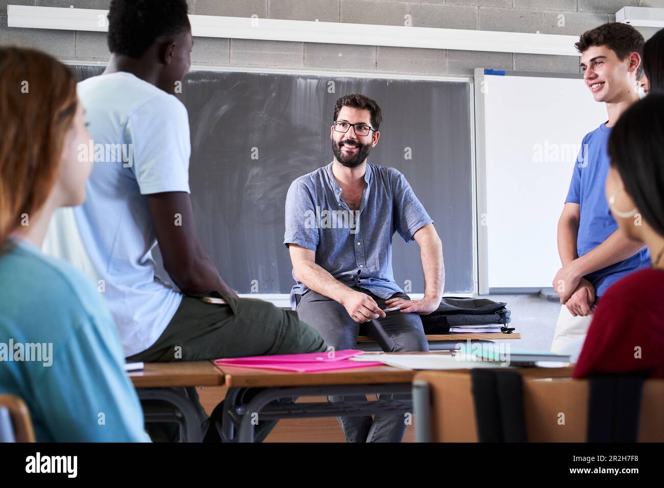 Secondary student being helped by professor in classroom. Malee ...