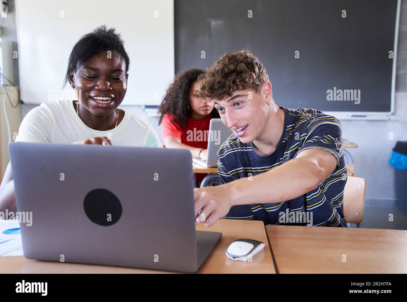 Group Of Teenage Students using laptop Collaborating On Project In ...