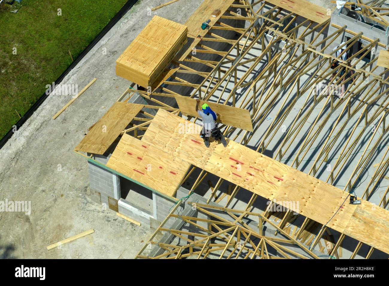 Professional builders working on roof construction of unfinished ...