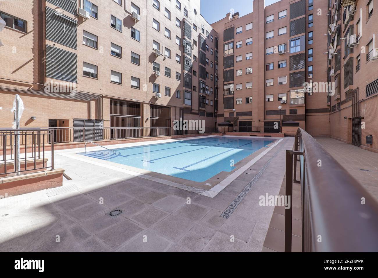 Pool within a community of neighbors with some showers and stone floors ...
