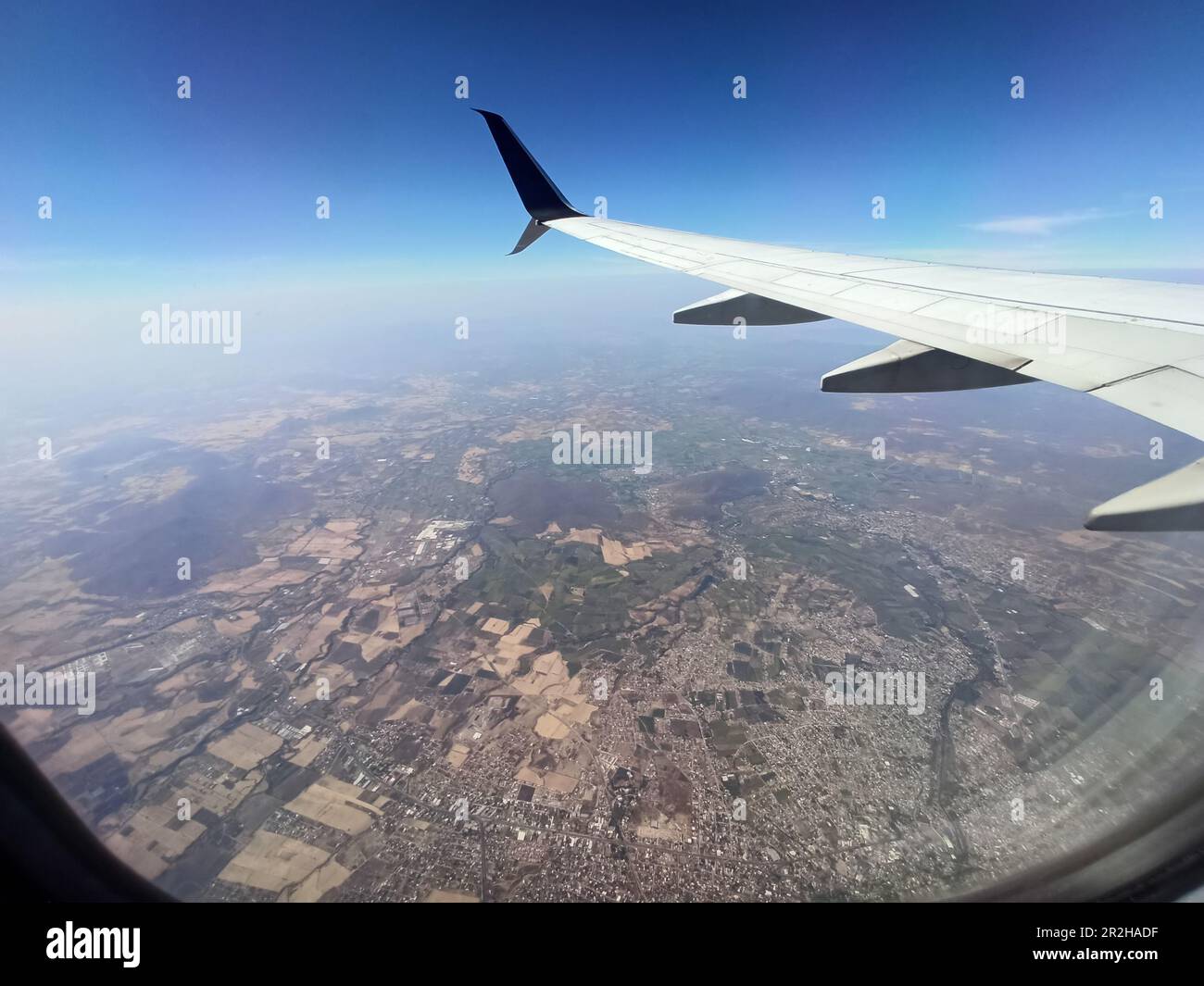 View through airplane window of commercial jet plane wing flying high ...