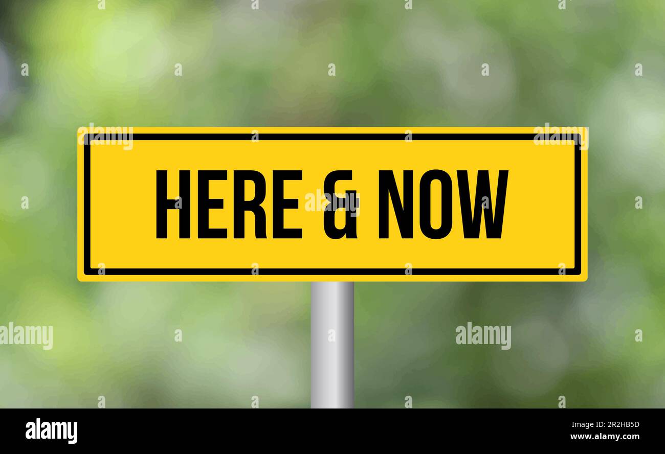 Here & now road sign on blur background Stock Photo - Alamy