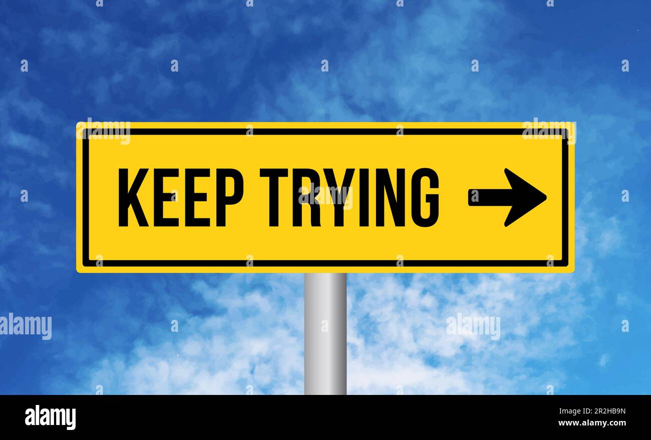 Keep trying road sign on blue sky background Stock Photo - Alamy